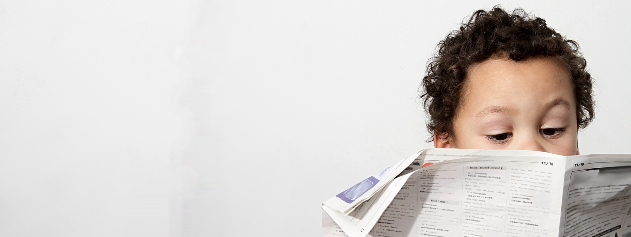 Little boy reading newspaper stock photo - JWB